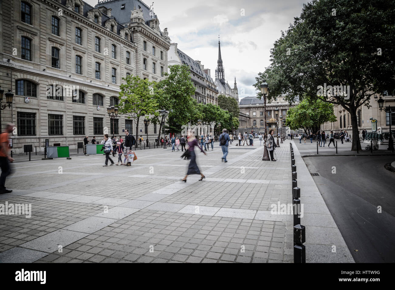 People Walking in teh streets of Paris, in the back Sainte Chapelle ...