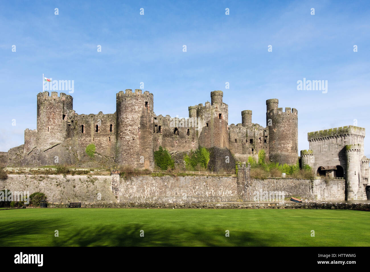 Conwy castle battlements on towers and walls with Welsh flag flying ...