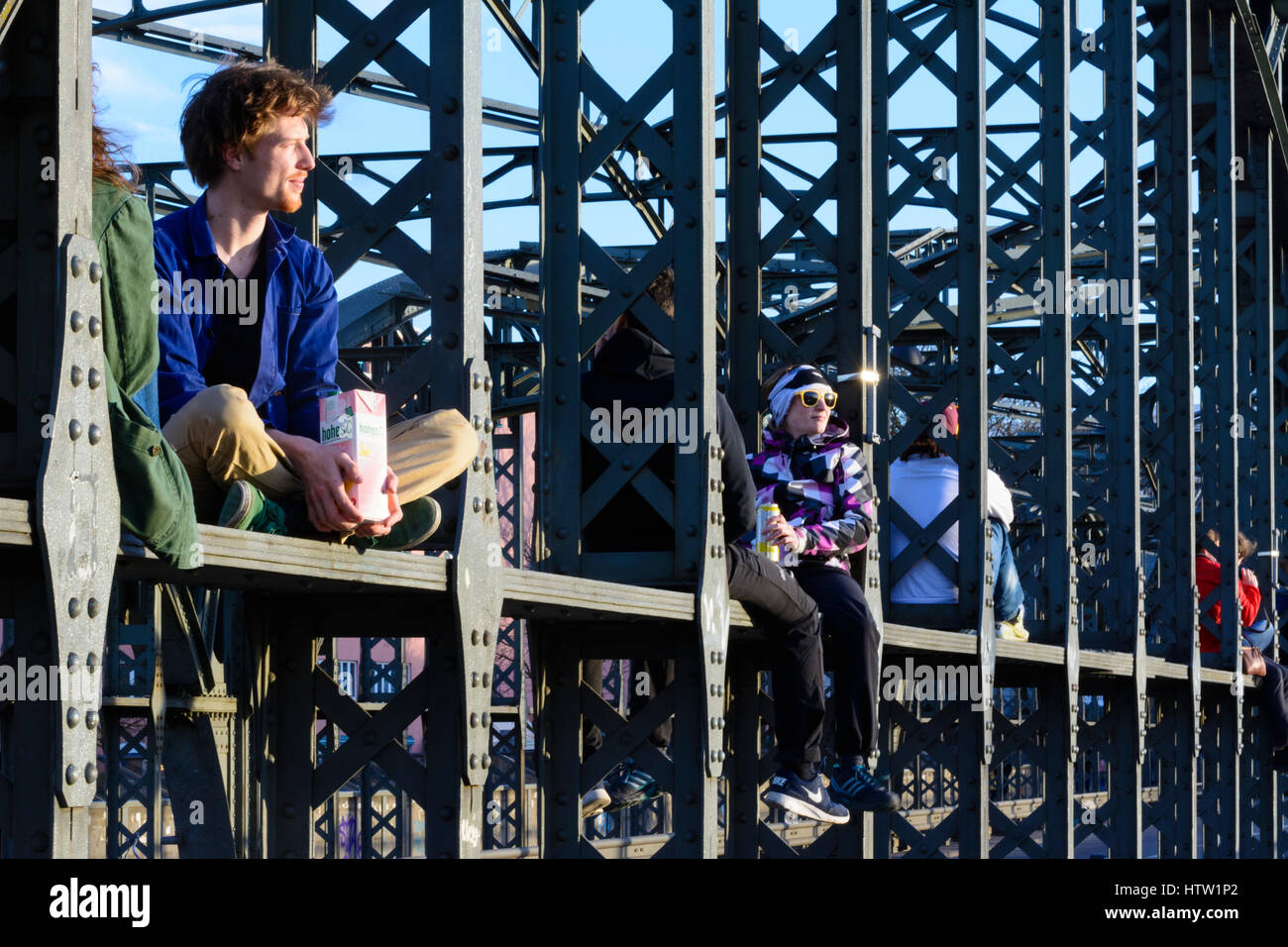 München, Munich, people sitting in the framework of road bridge ...