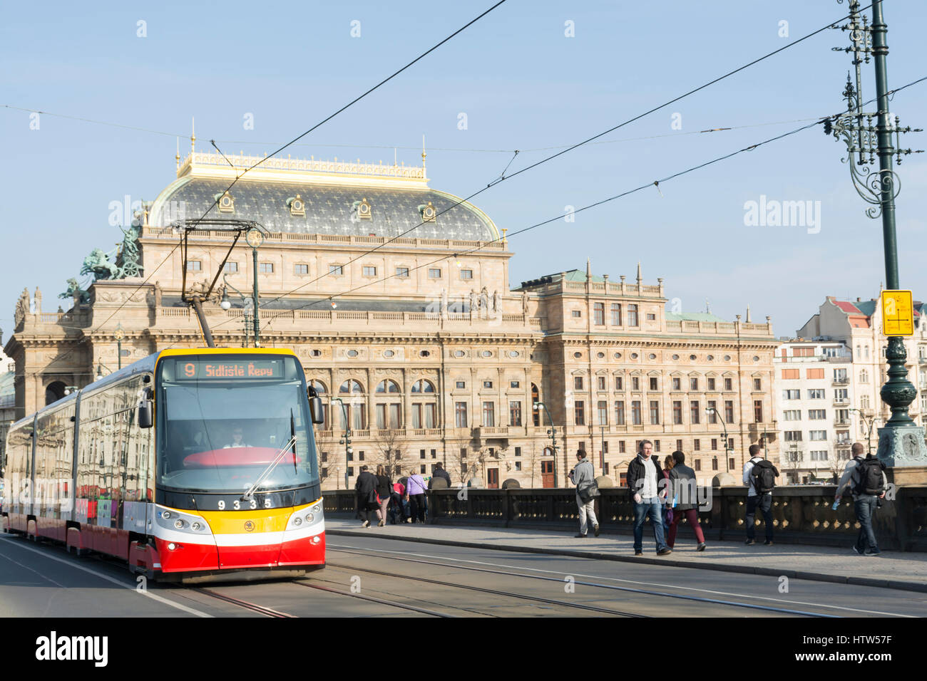 A tram crossing the legion bridge in Prague, with National Theater in ...