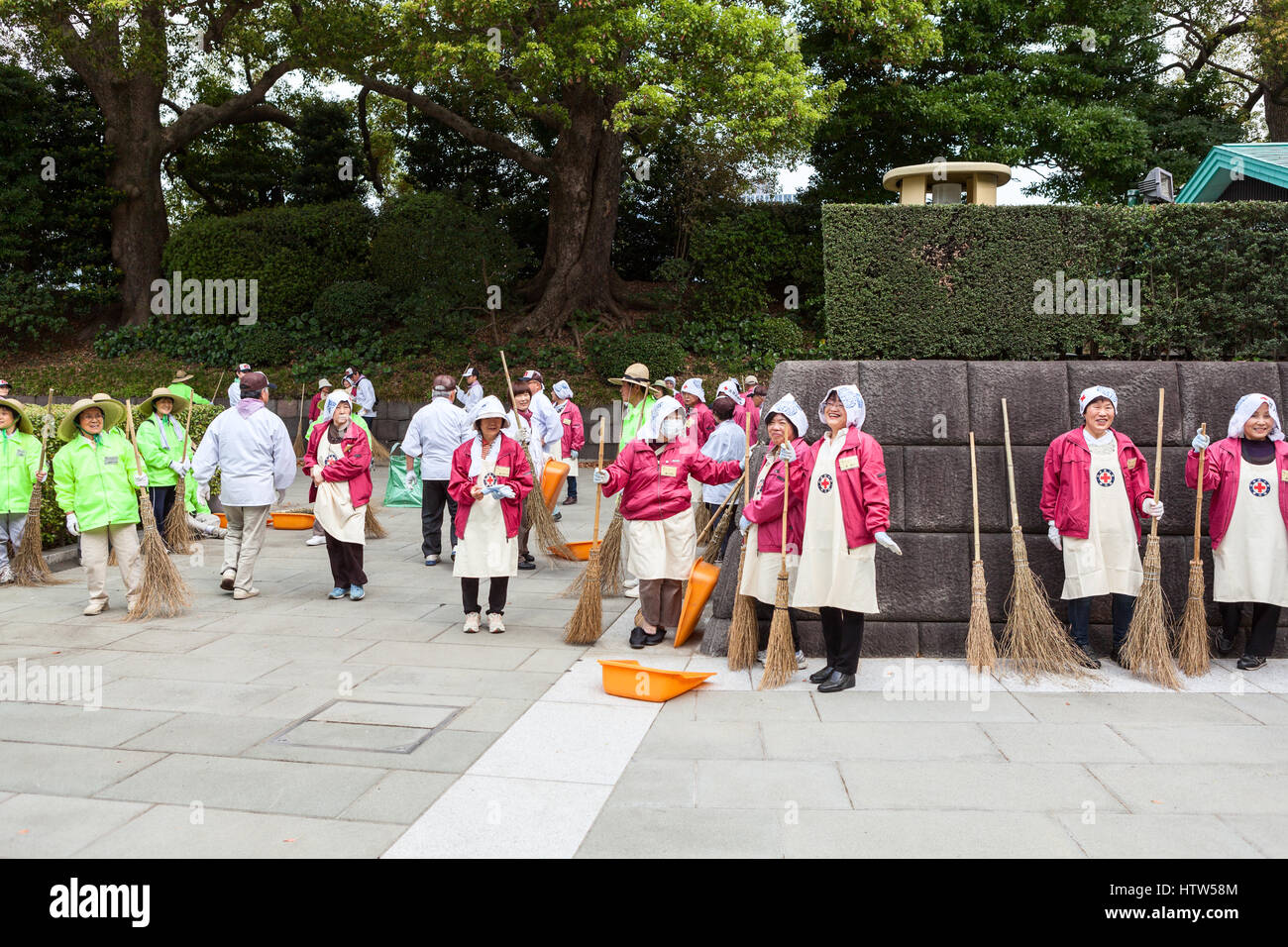 TOKYO, JAPAN - CIRCA APR, 2013: Cleaning workers with brooms in colors ...