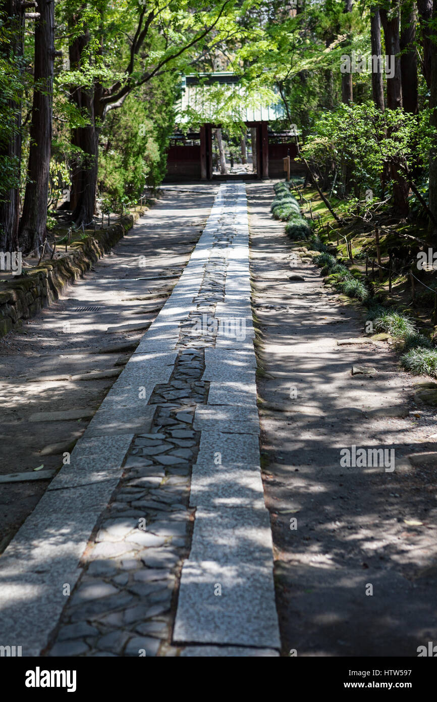 Long stone pathway and wooden gate in Japanese shrine. Kamakura, Japan ...