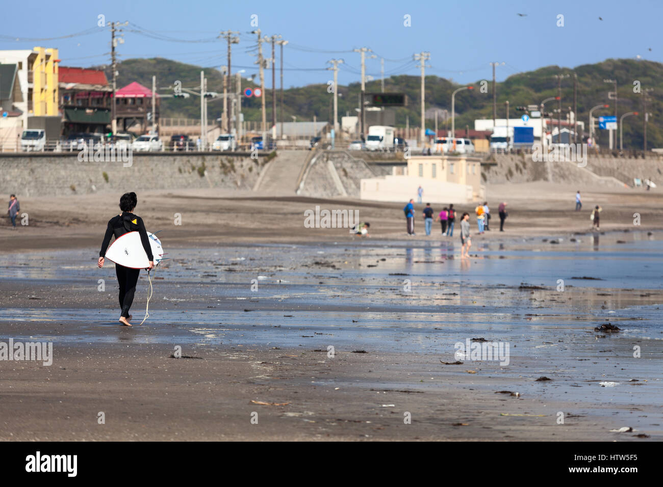 KAMAKURA, JAPAN - CIRCA APR, 2013: Japanese man a surfer walks on low ...