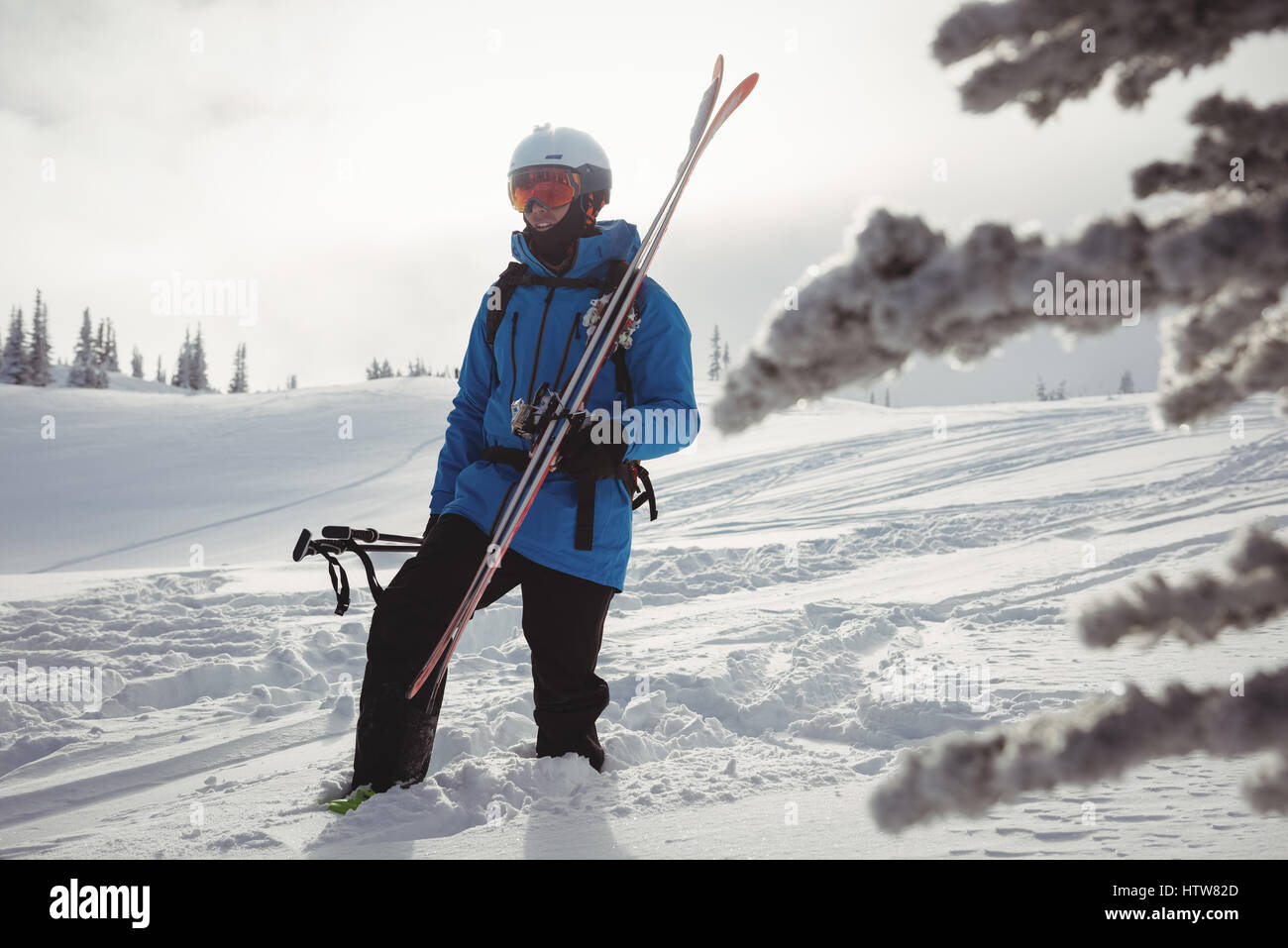 Skier walking with ski on snowy mountain Stock Photo - Alamy