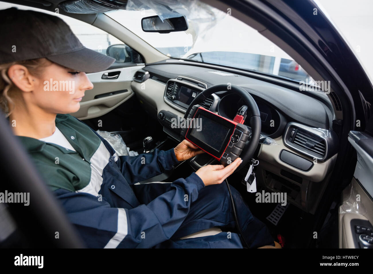 Female mechanic using electronic diagnostic device Stock Photo - Alamy