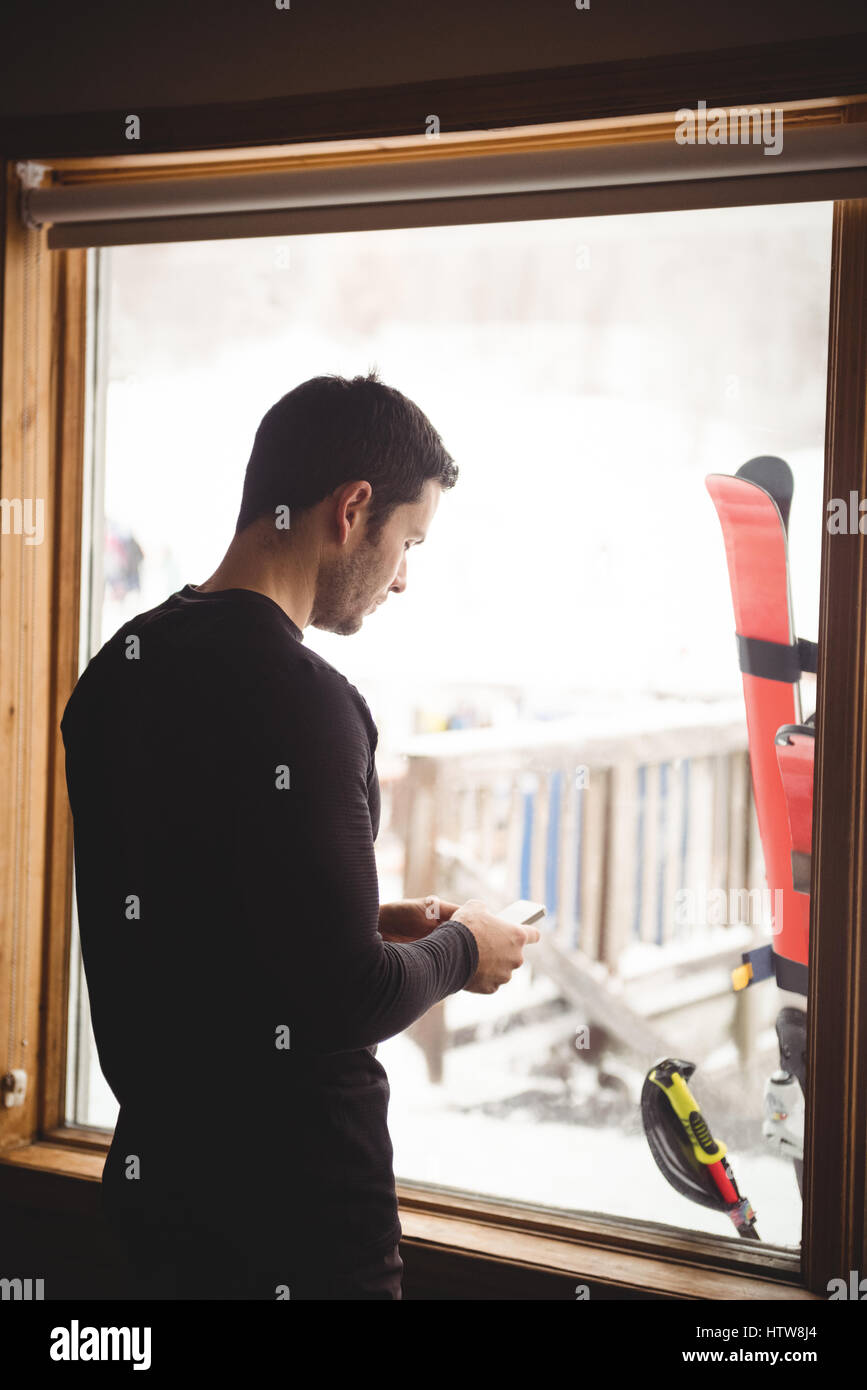 Man on his phone in front of window Stock Photo - Alamy