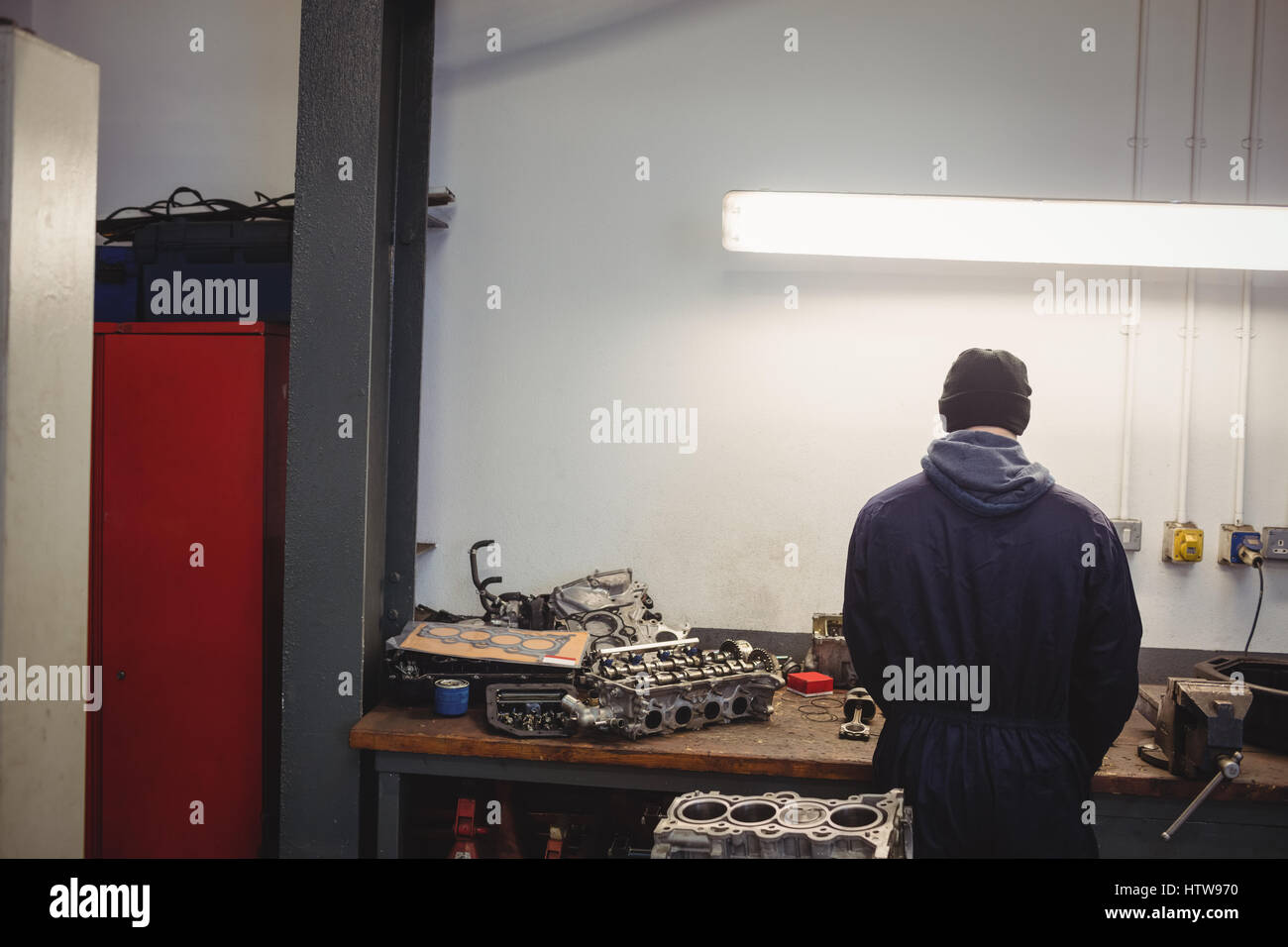 Rear view of mechanic working in garage Stock Photo - Alamy
