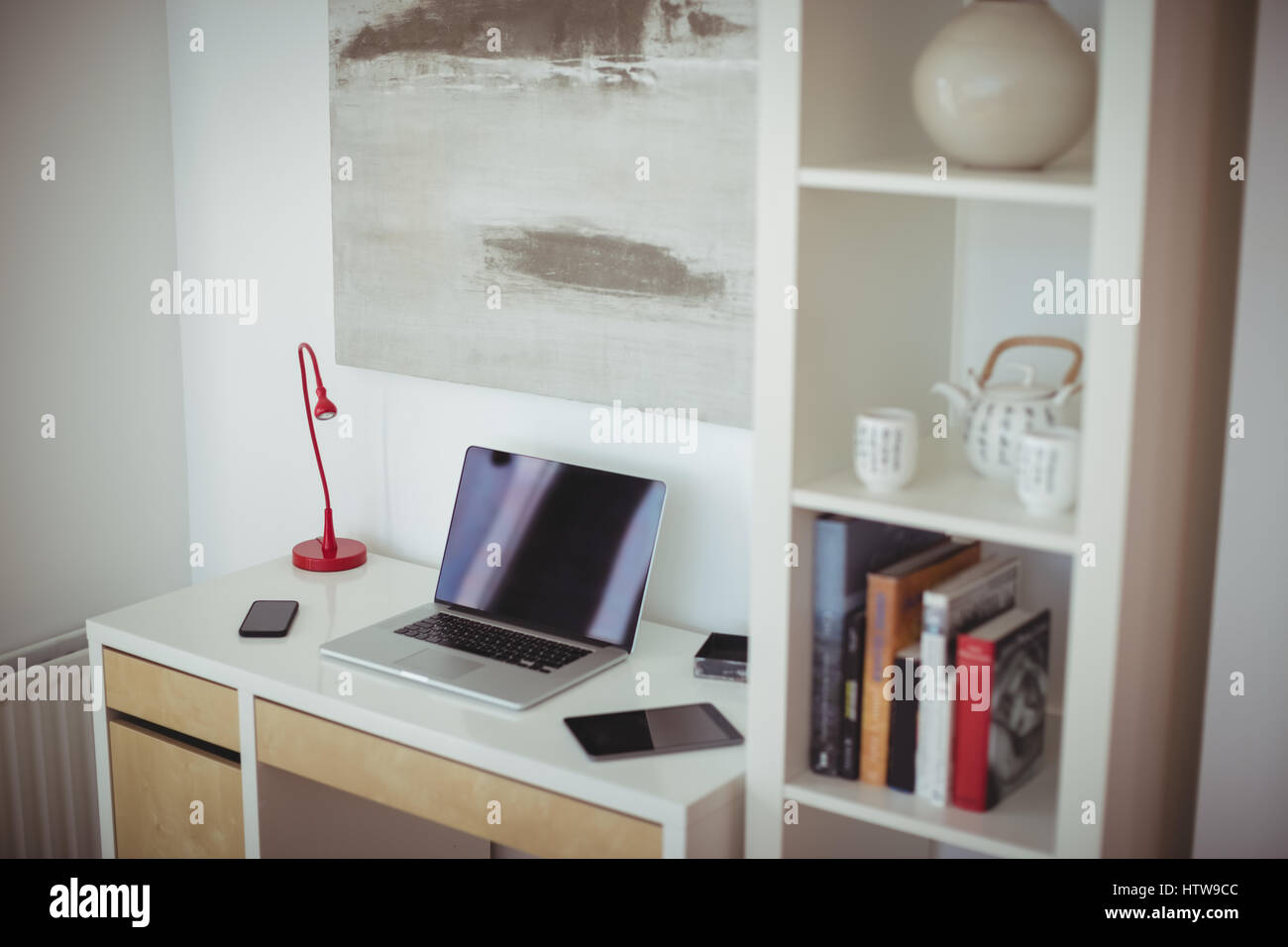 Laptop, digital tablet and mobile phone kept on table in study room ...