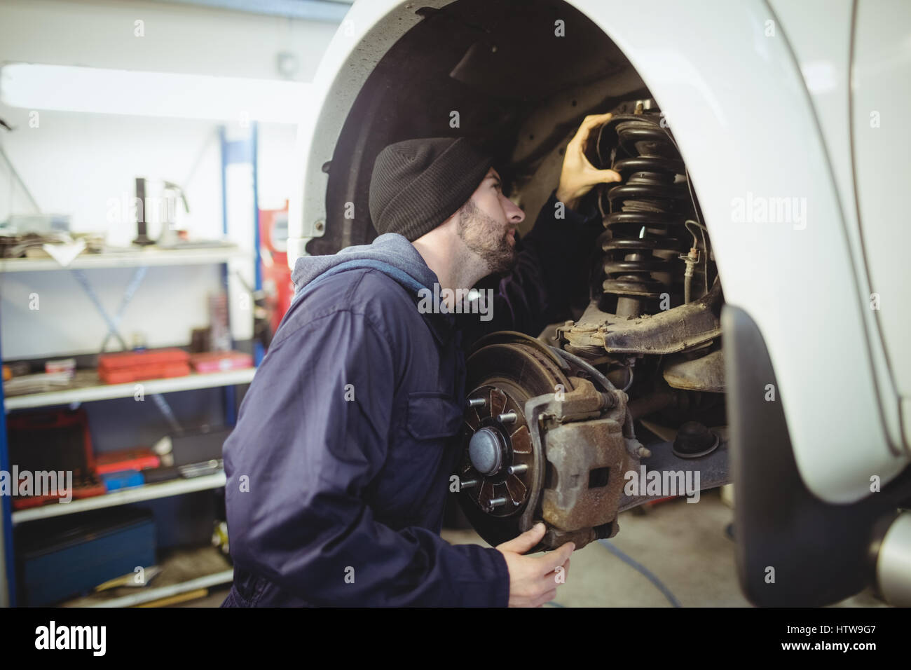 Mechanic examining a car wheel disc brake Stock Photo - Alamy