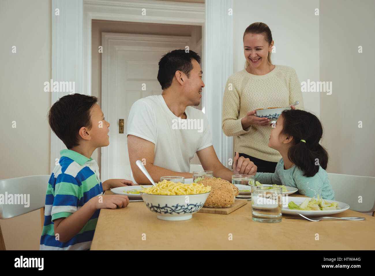 Happy family having meal Stock Photo - Alamy