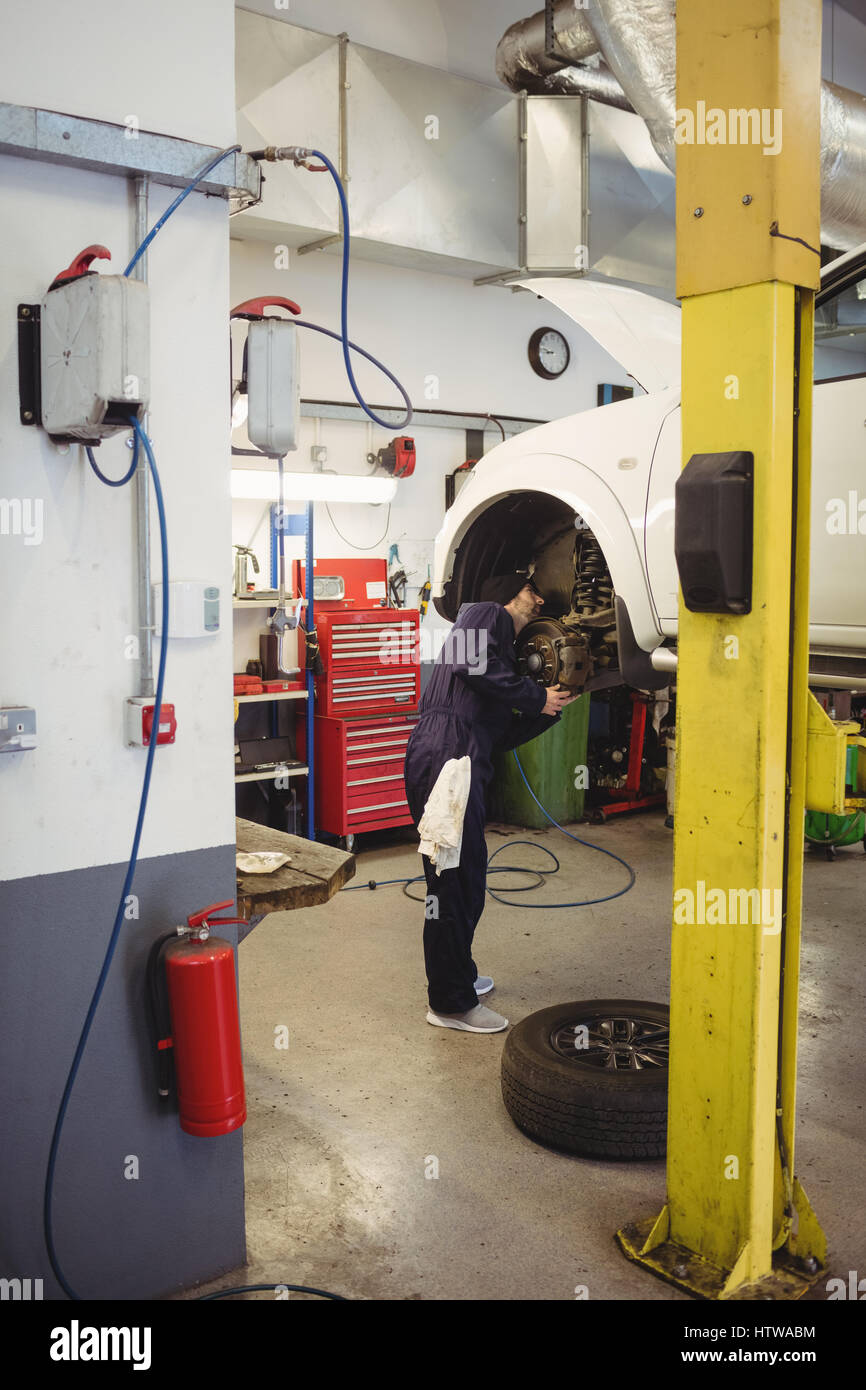 Mechanic examining a car wheel disc brake Stock Photo - Alamy