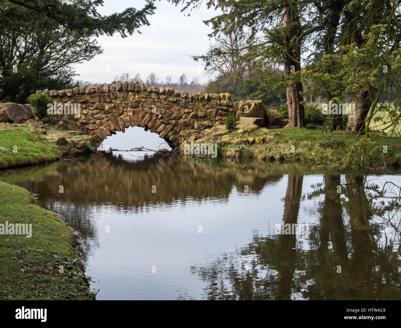 A traditional stone footbridge seen over the Serpentine river in ...