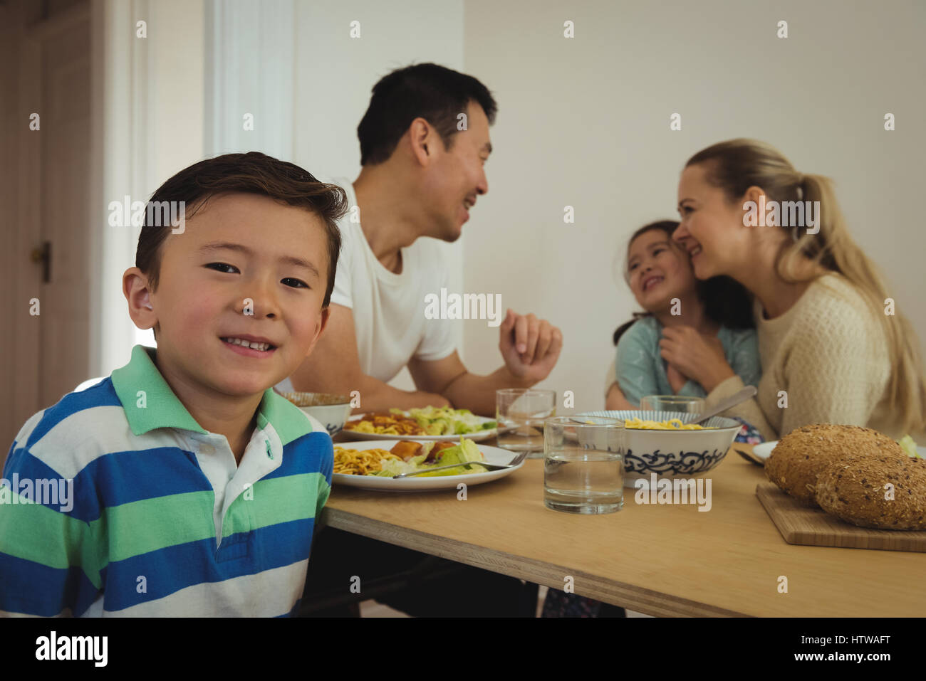 Portrait of boy smiling while family having meal in background Stock ...