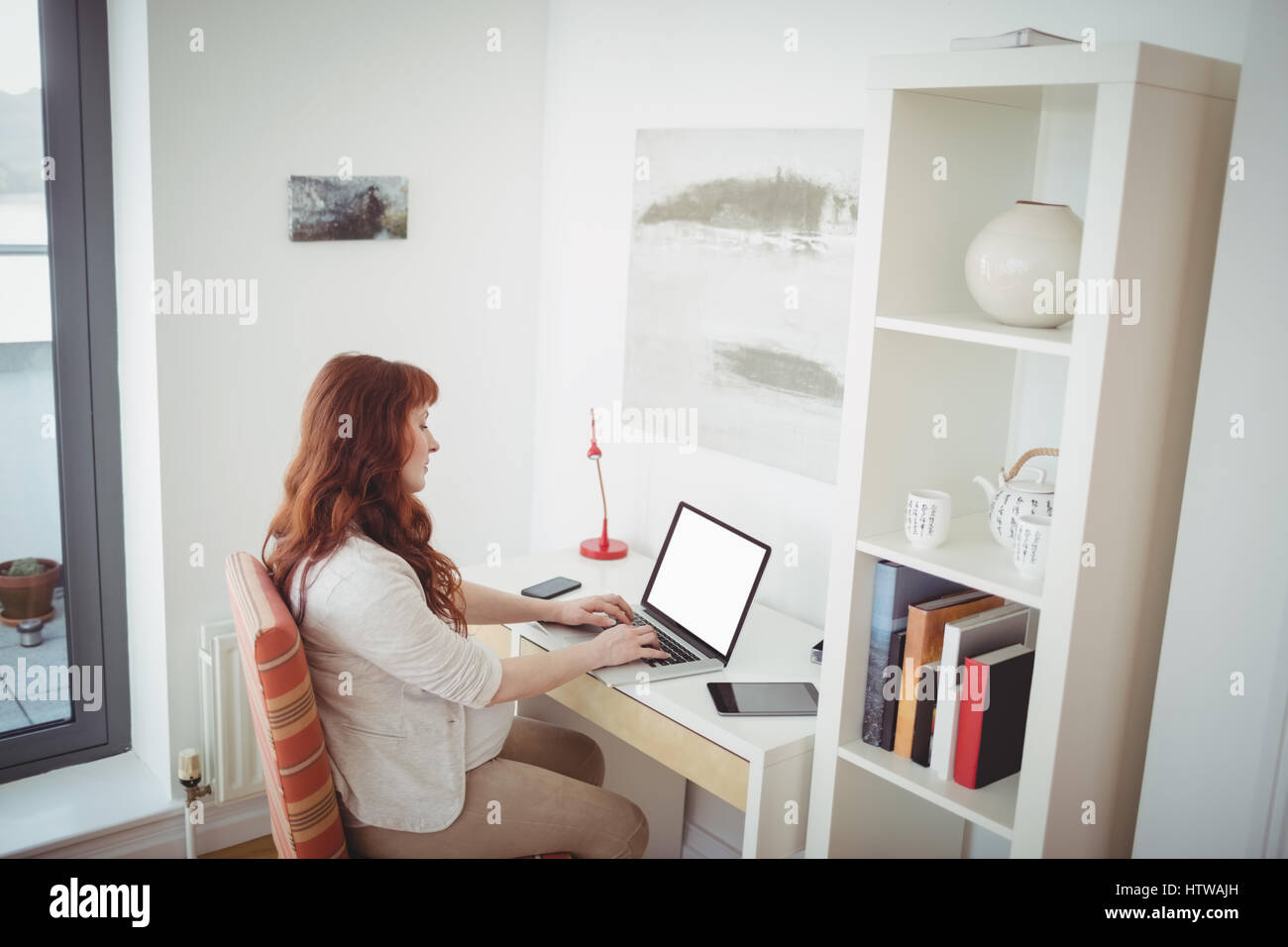 Pregnant woman using laptop in study room Stock Photo - Alamy