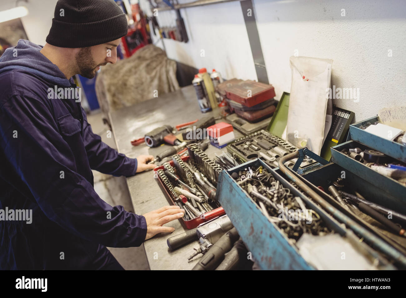 Mechanic looking at tools in garage Stock Photo - Alamy