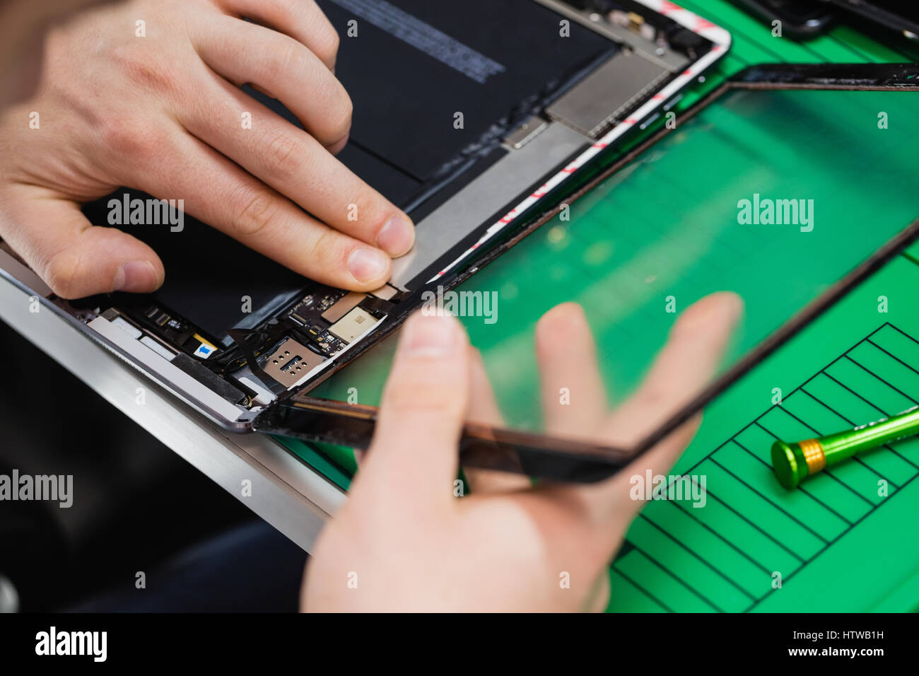 Man repairing digital tablet Stock Photo - Alamy