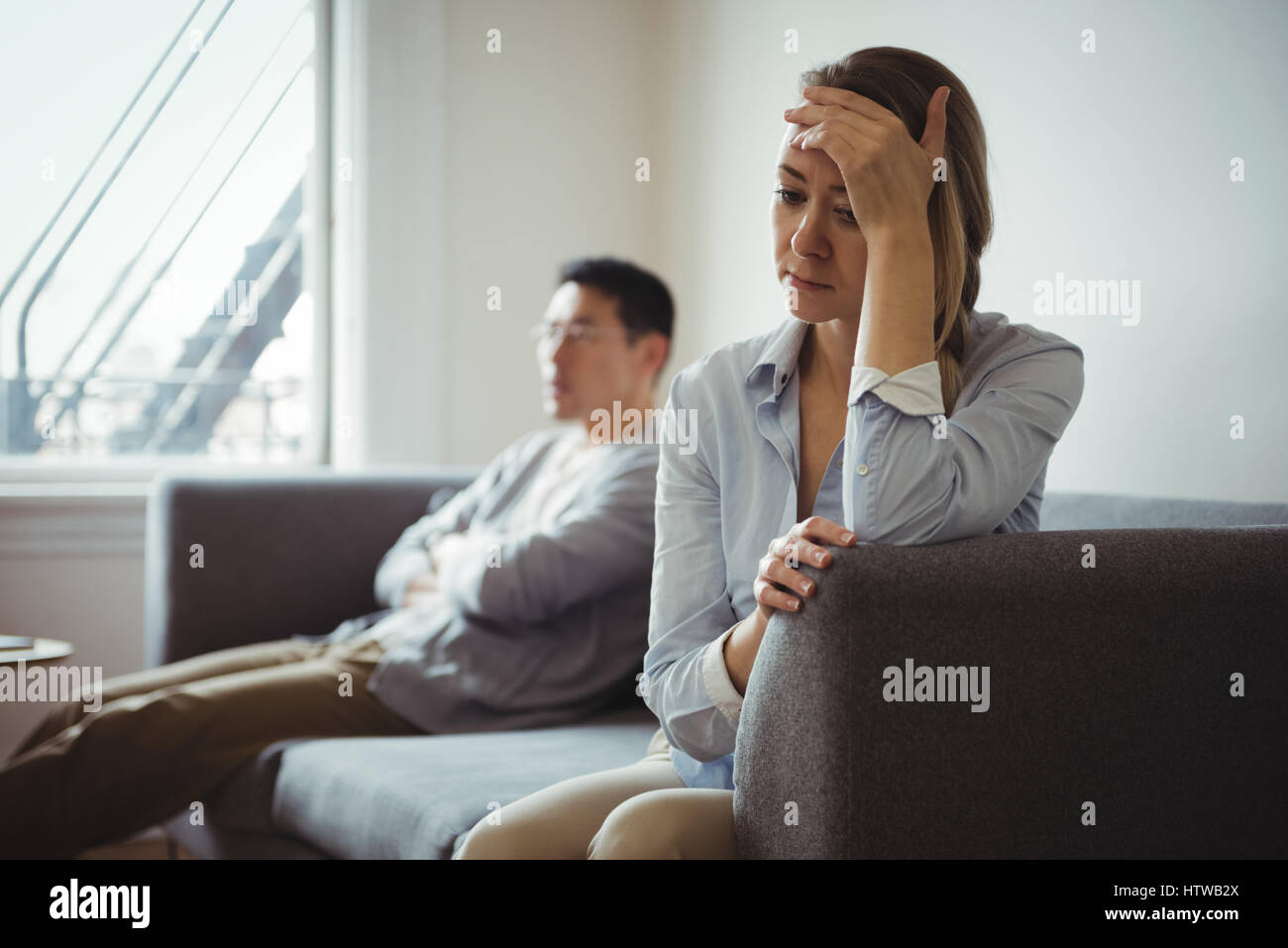Couple sitting on sofa and ignoring each other Stock Photo - Alamy