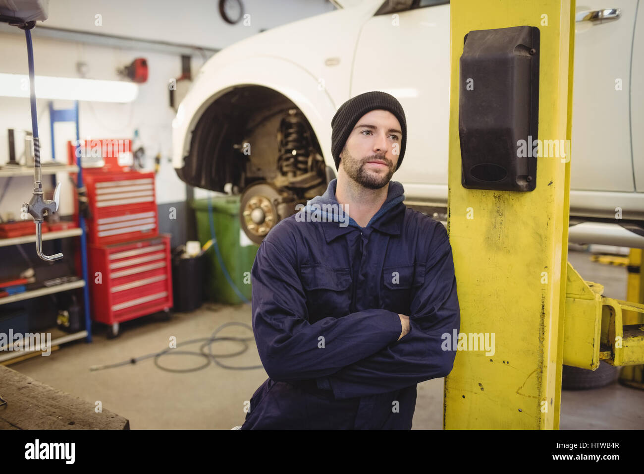 Mechanic standing with arms crossed Stock Photo - Alamy