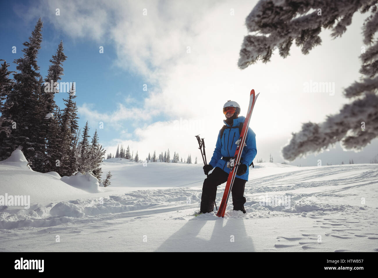 Skier walking with ski on snowy mountain Stock Photo - Alamy