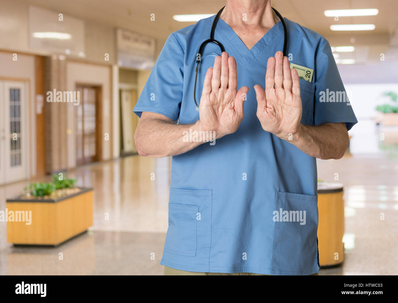 Senior doctor in scrubs refusing entry Stock Photo - Alamy