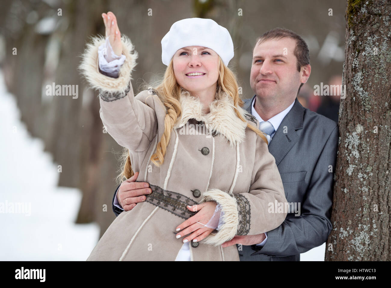 Portrait of loving wedding couple standing leaning tree and embracing ...