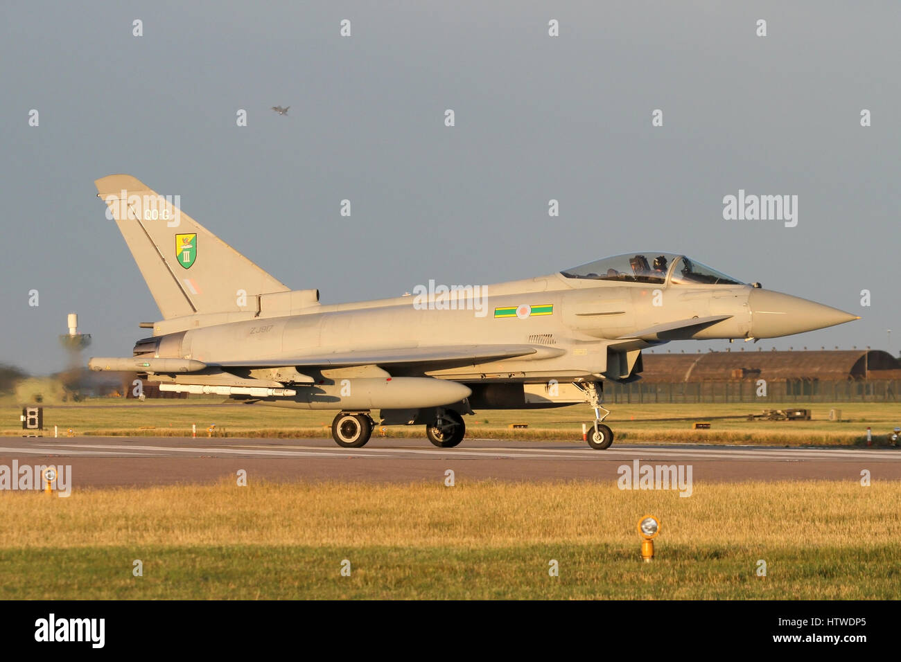 One RAF Typhoon turning off the runway at RAF Coningsby as another ...