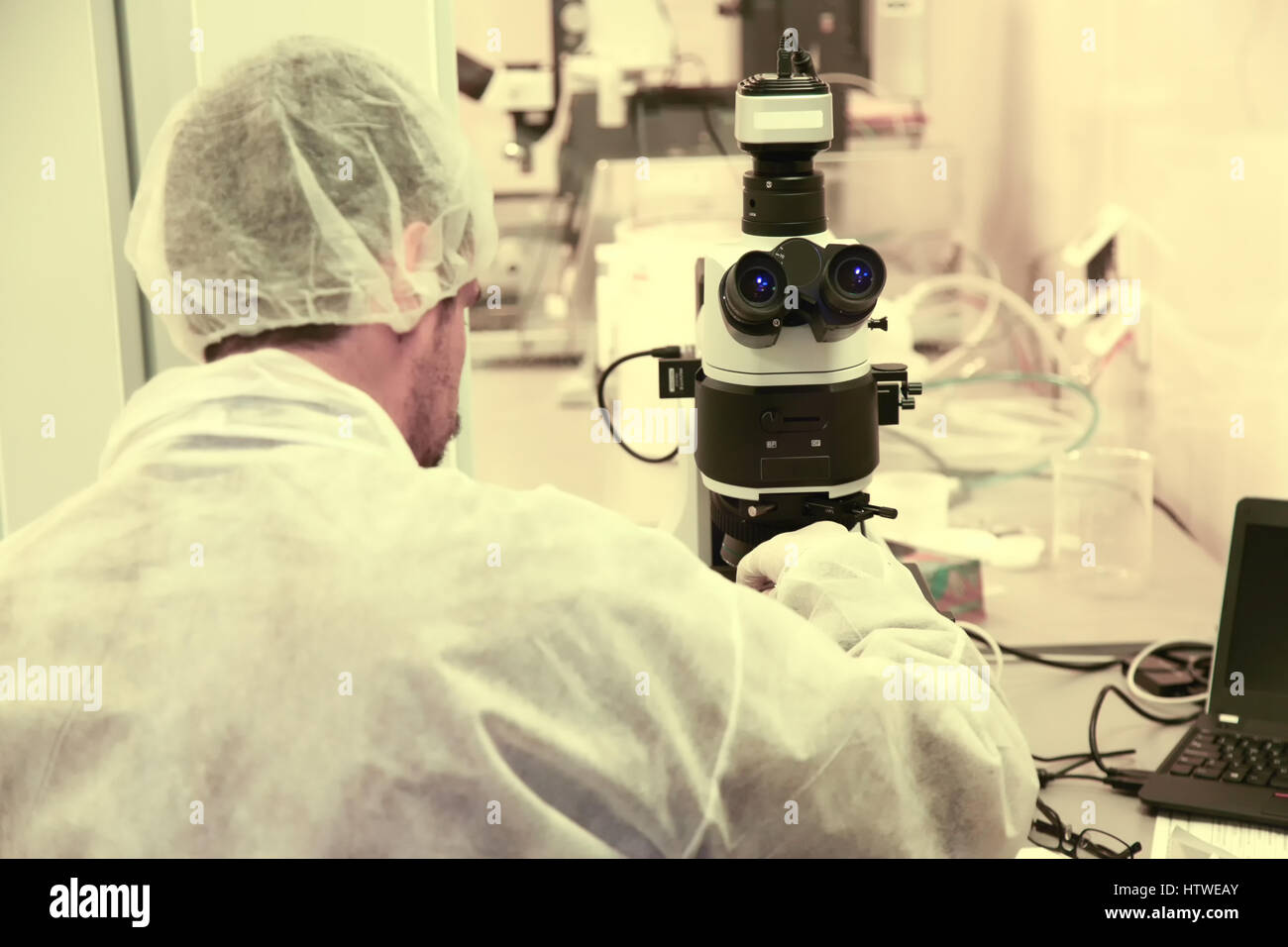 Laboratory technician using microscope in high tech laboratory Stock ...