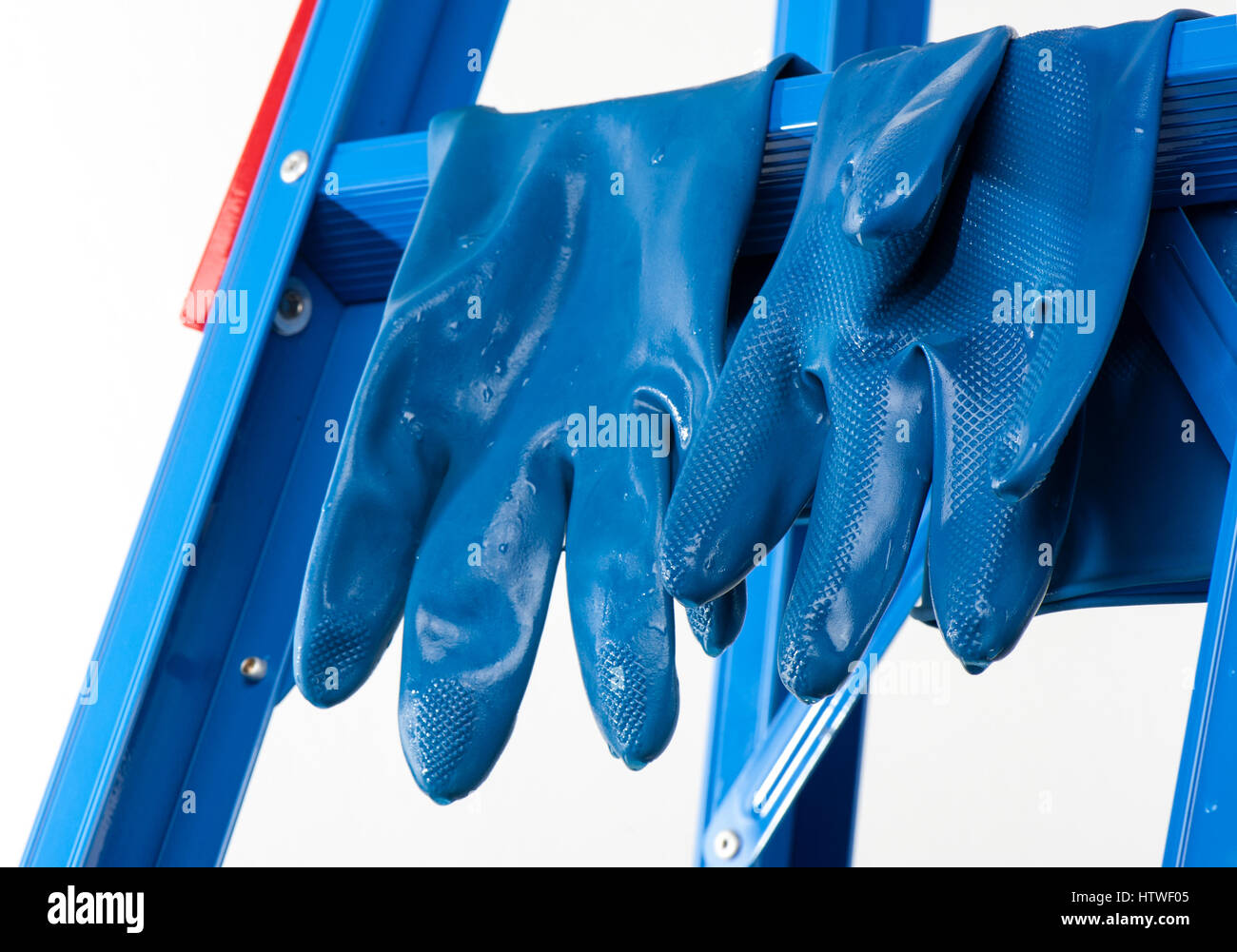 wet blue rubber glove hanging on ladder, personal protection equipment ...