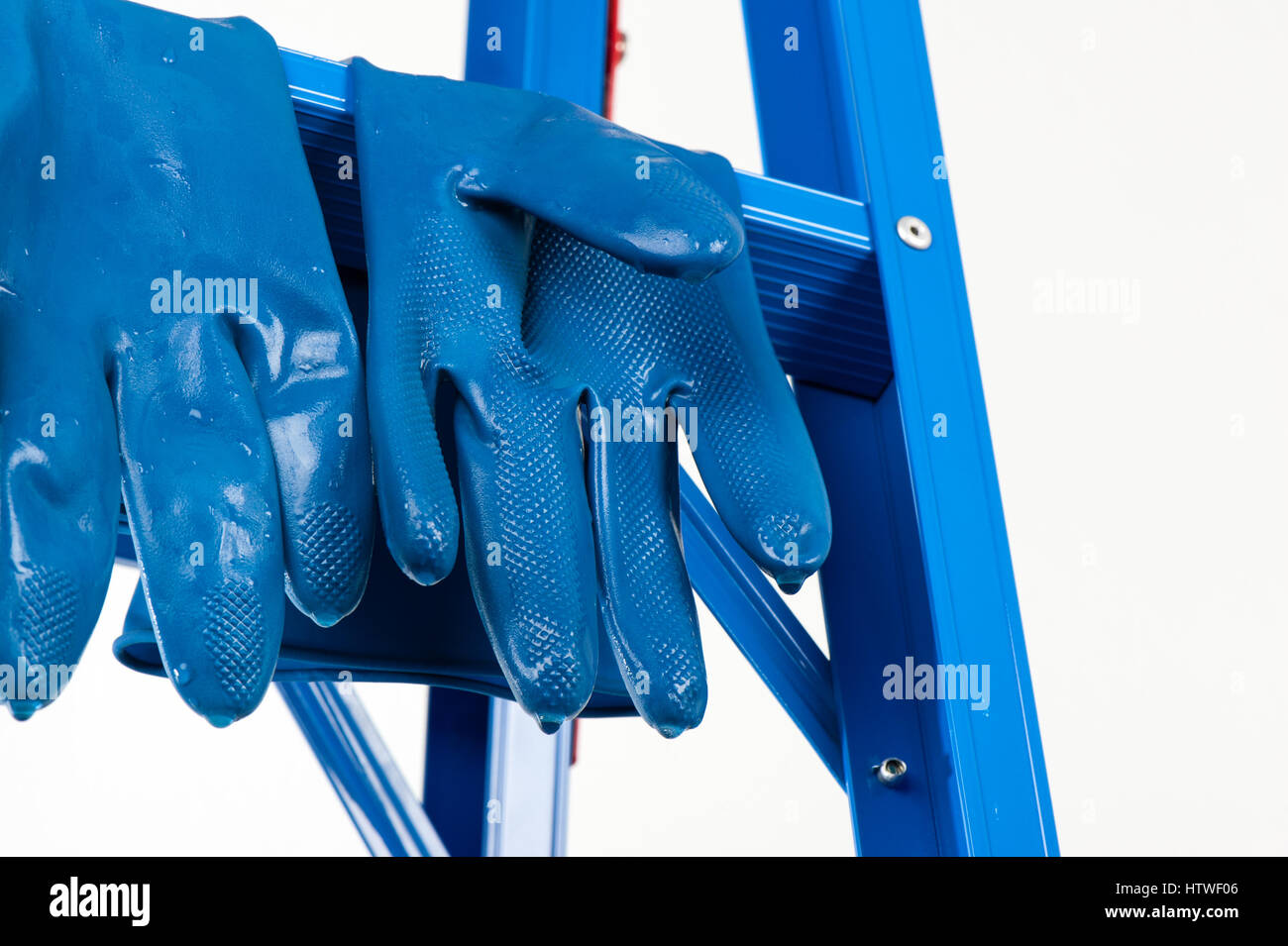 wet blue rubber glove hanging on ladder, personal protection equipment ...