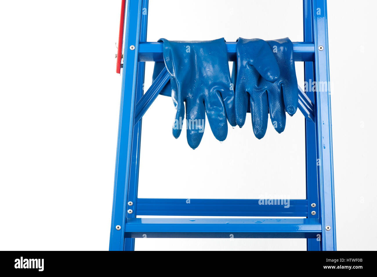 wet blue rubber glove hanging on ladder, personal protection equipment ...