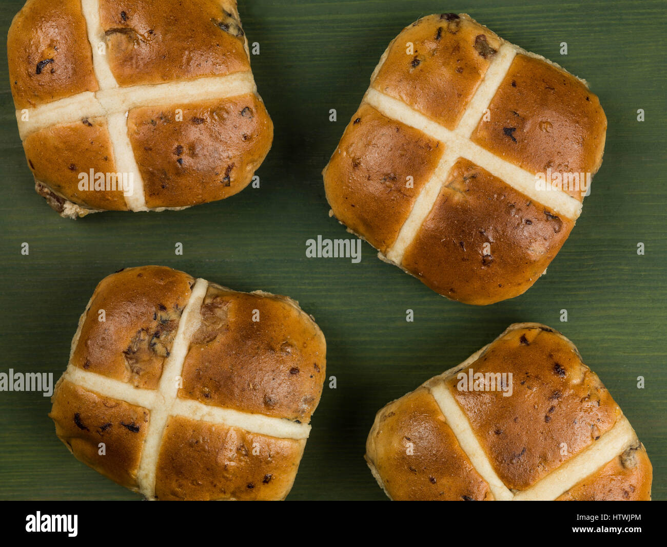 Four Hot Cross Buns Against a Green Background Stock Photo - Alamy