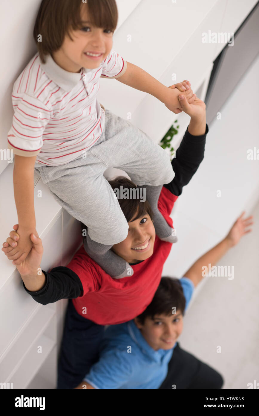 happy young boys having fun and posing line up piggyback in new modern ...