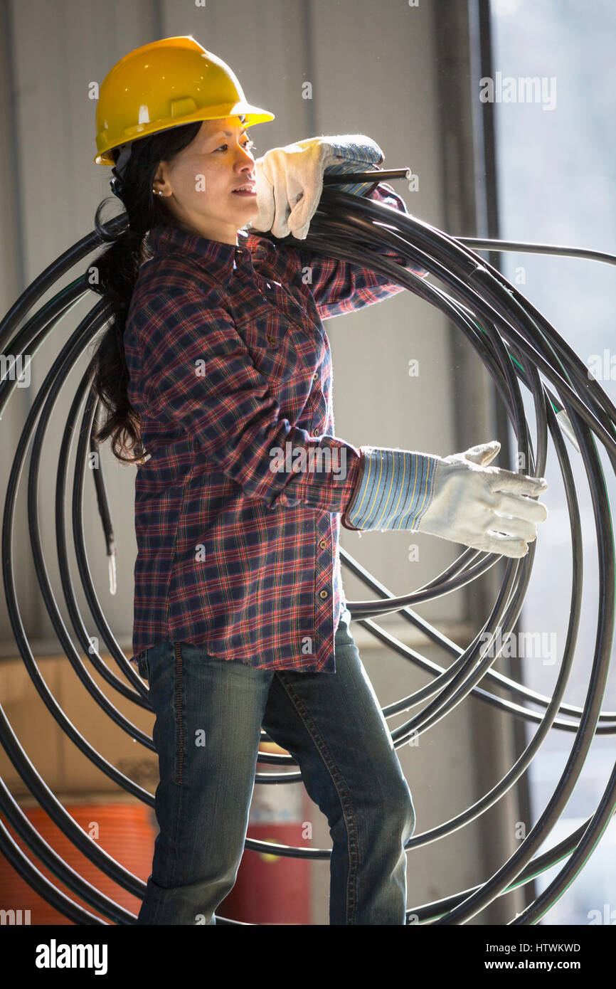Female power engineer with power cable in service garage Stock Photo ...