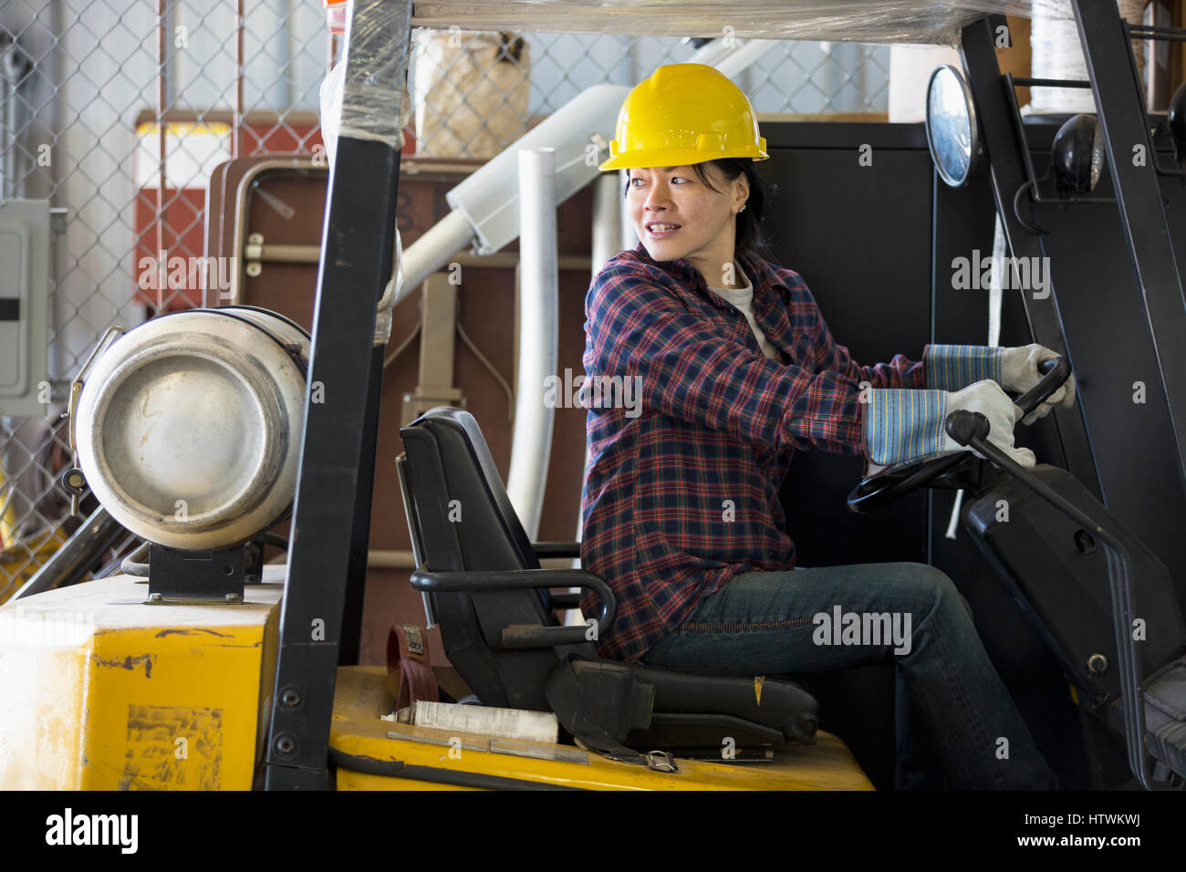 Female power engineer driving a forklift truck in service garage Stock ...