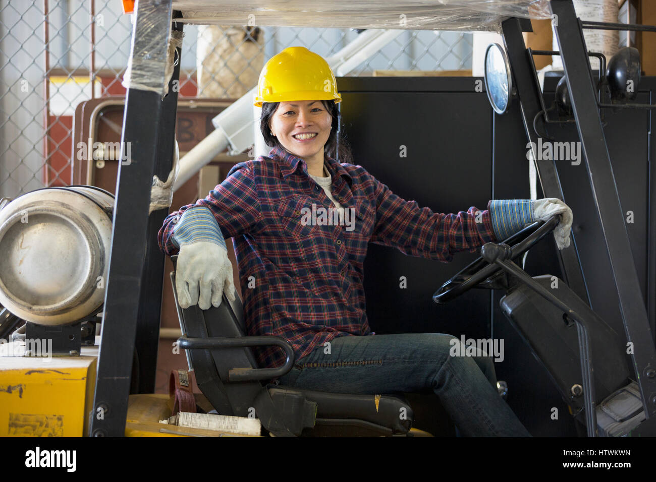 Female power engineer driving a forklift truck in service garage Stock ...