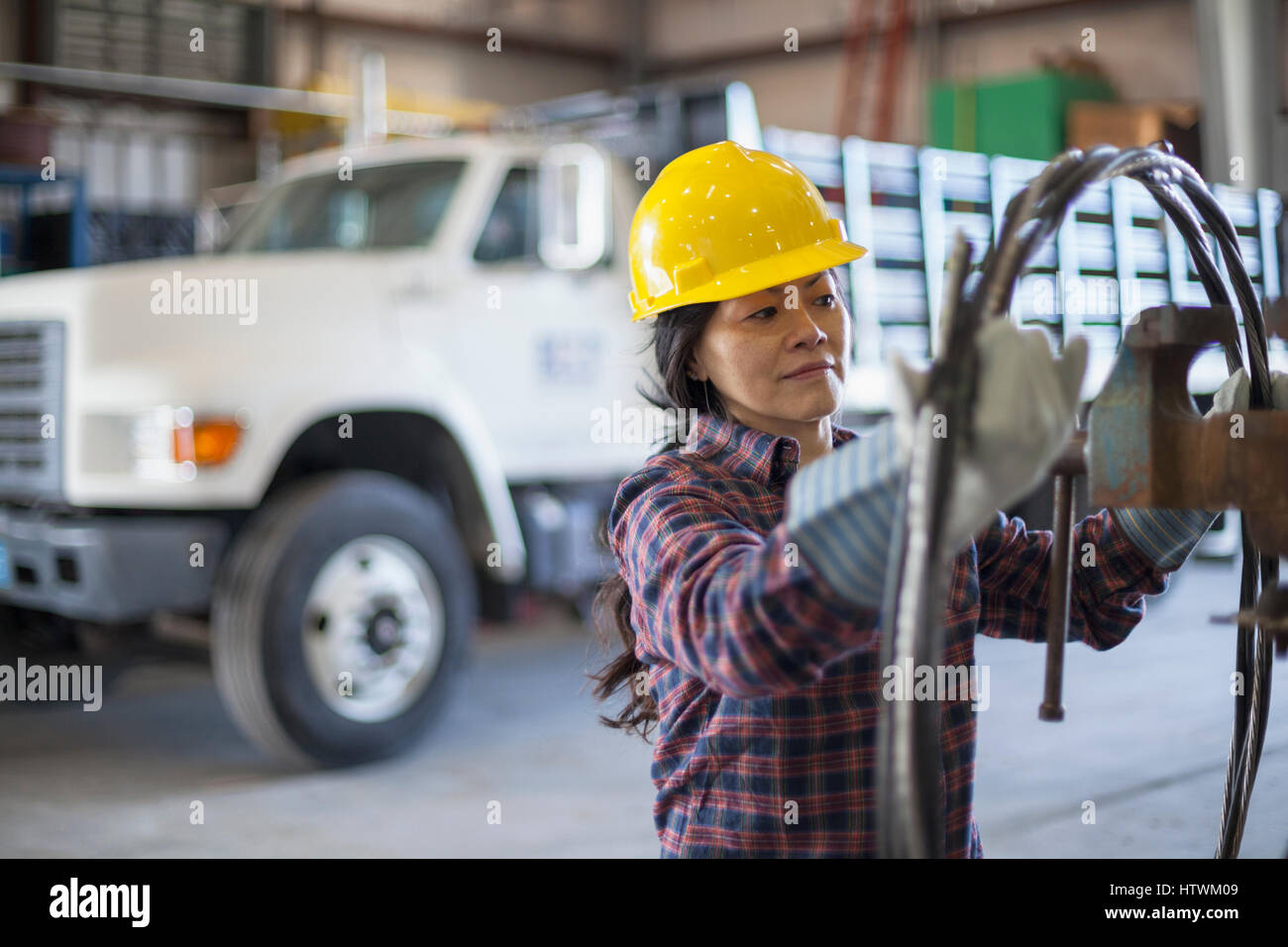 Female power engineer with power cable in service garage Stock Photo ...