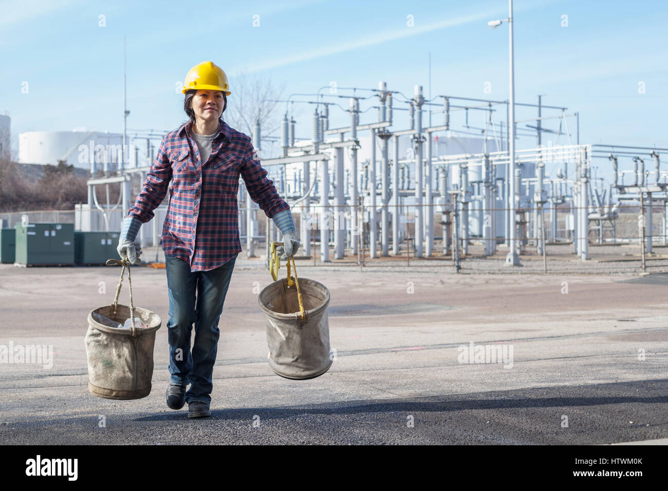 Female power engineer with canvas buckets at a power plant Stock Photo ...