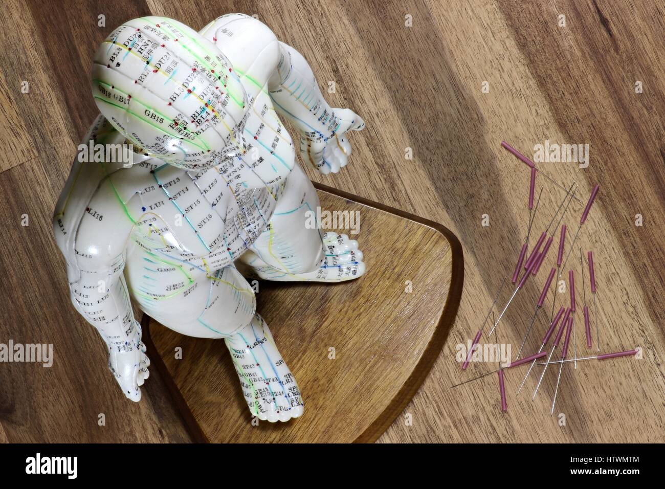 female acupuncture model on wooden background Stock Photo - Alamy