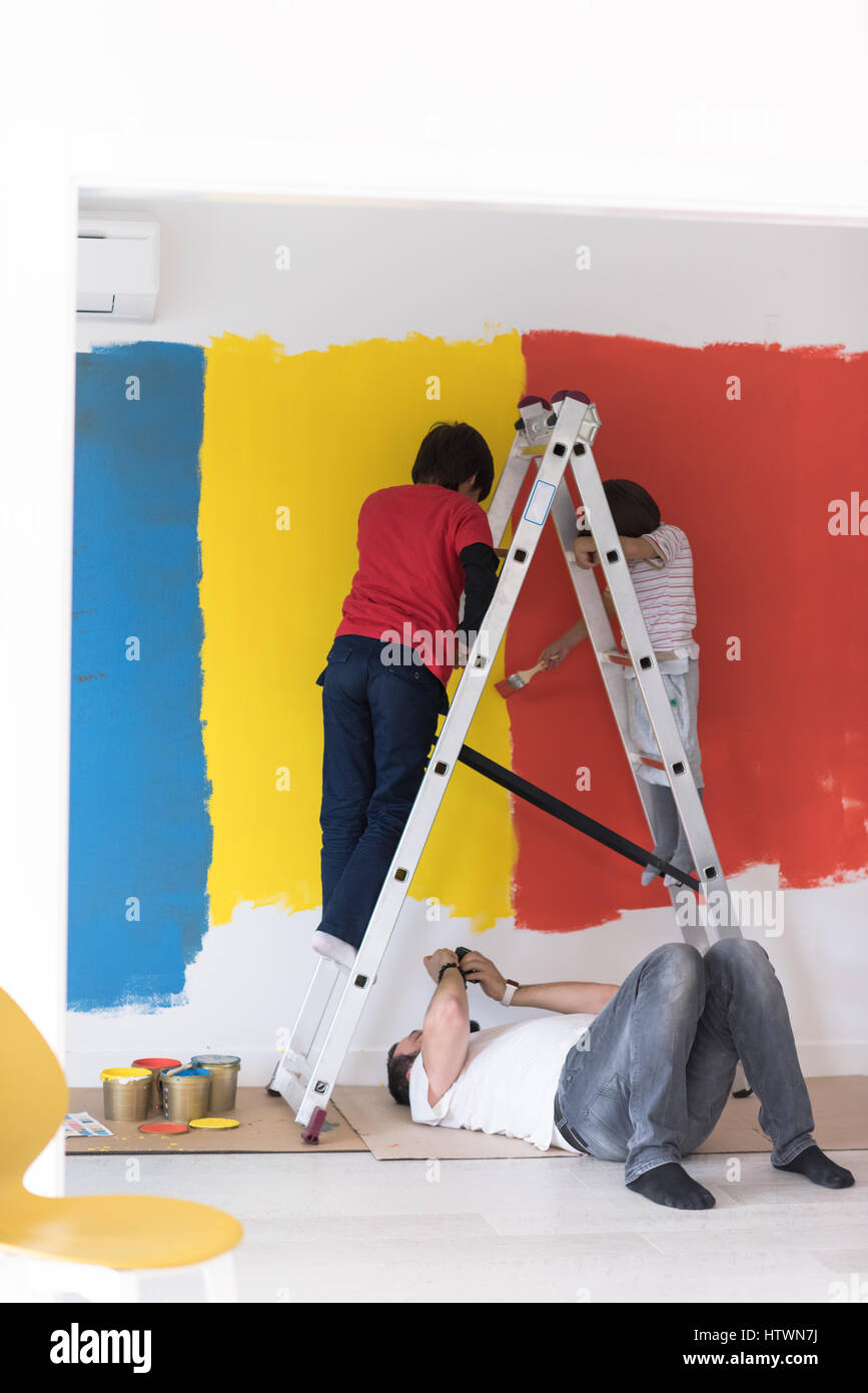 a group of young boys helps to paint a wall in new home Stock Photo - Alamy