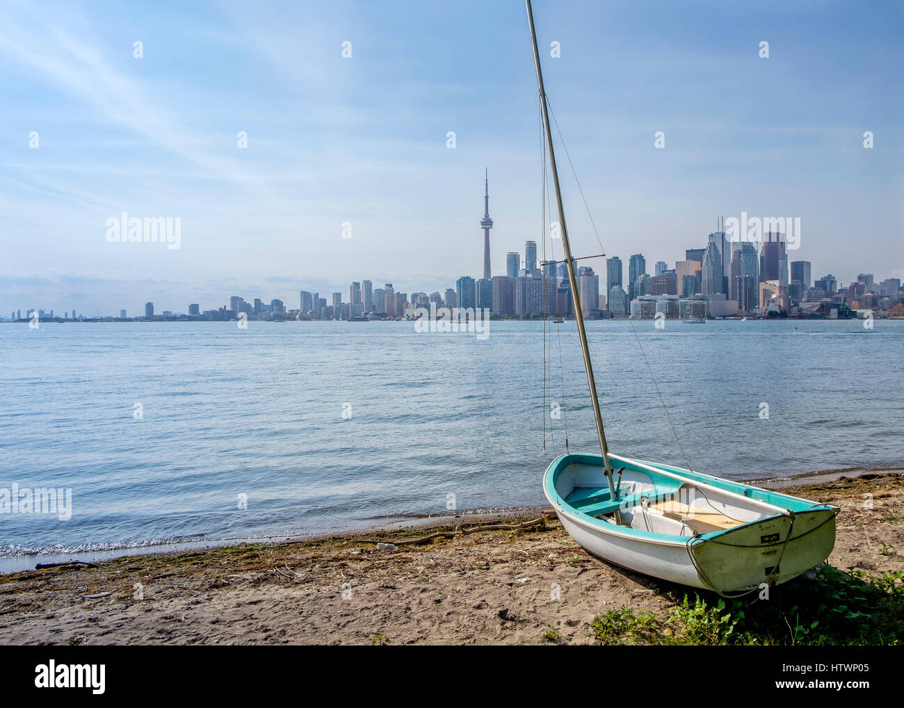A small white sailboat with seafoam green accents on a Toronto Islands ...