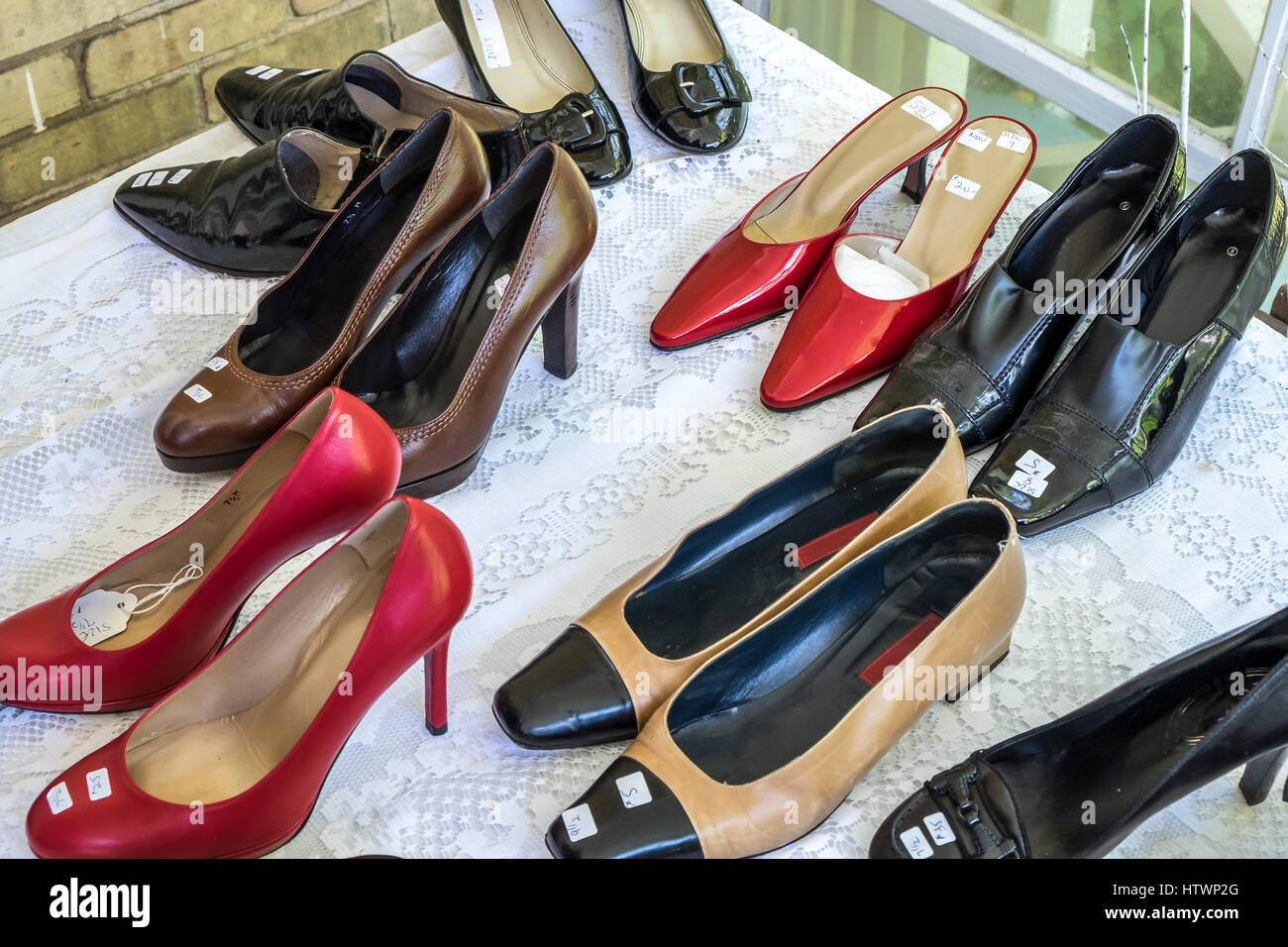 Pairs of women's shoes with price tags on a lace covered table Stock ...