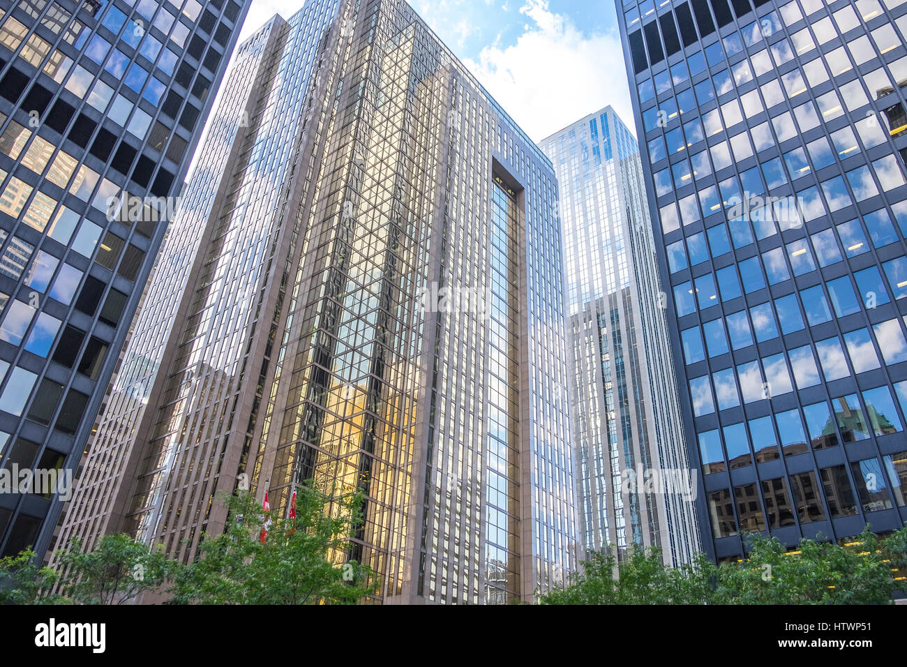 Office buildings of gold and black reflect the sun and blue cloudy sky ...