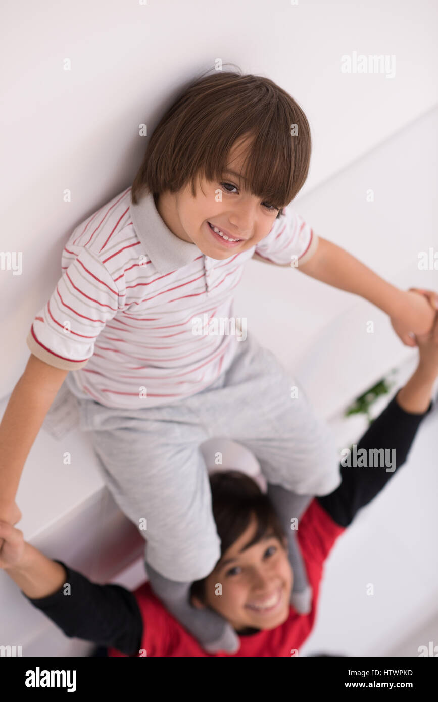happy young boys having fun and posing line up piggyback in new modern ...