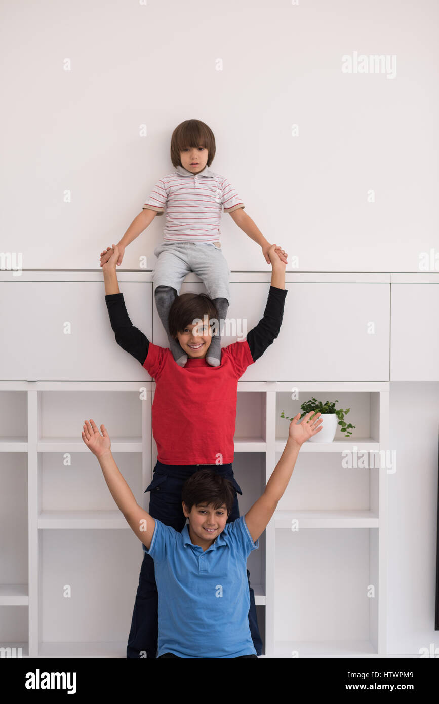 happy young boys having fun and posing line up piggyback in new modern ...