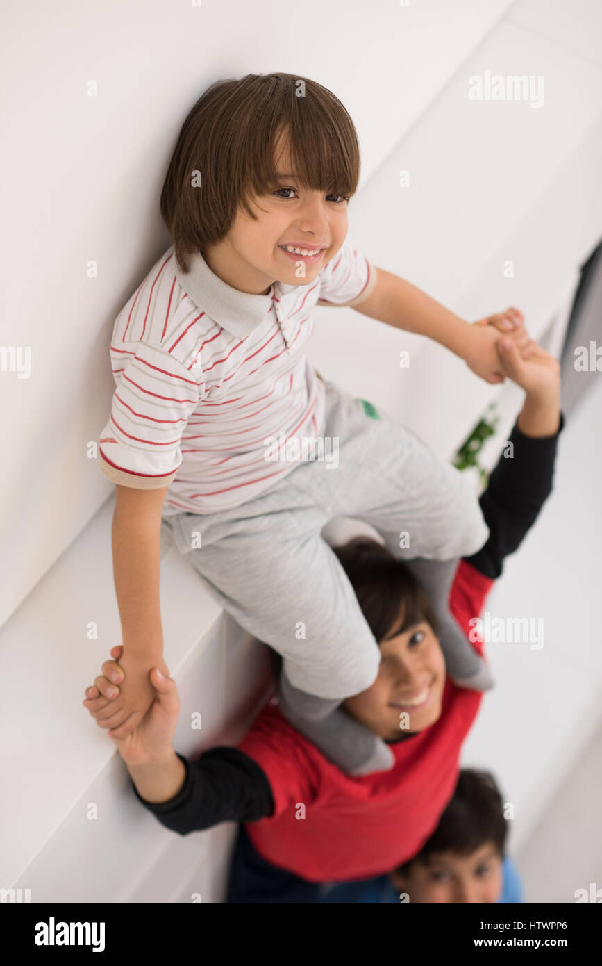 happy young boys having fun and posing line up piggyback in new modern ...