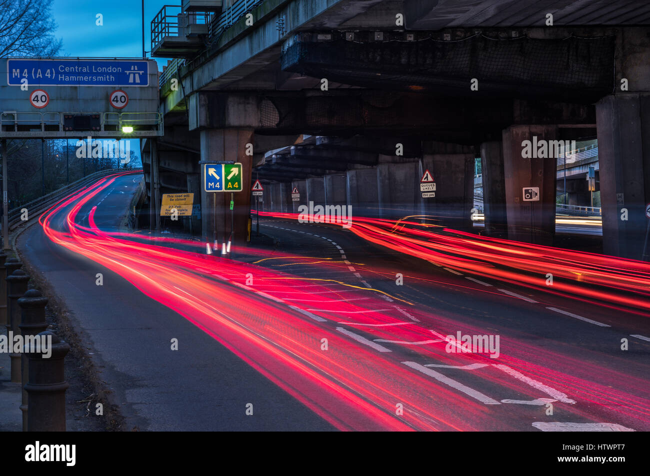 Traffic, cars with light trails along a busy road in London at rush ...