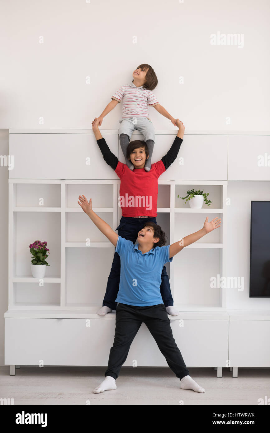 happy young boys having fun and posing line up piggyback in new modern ...