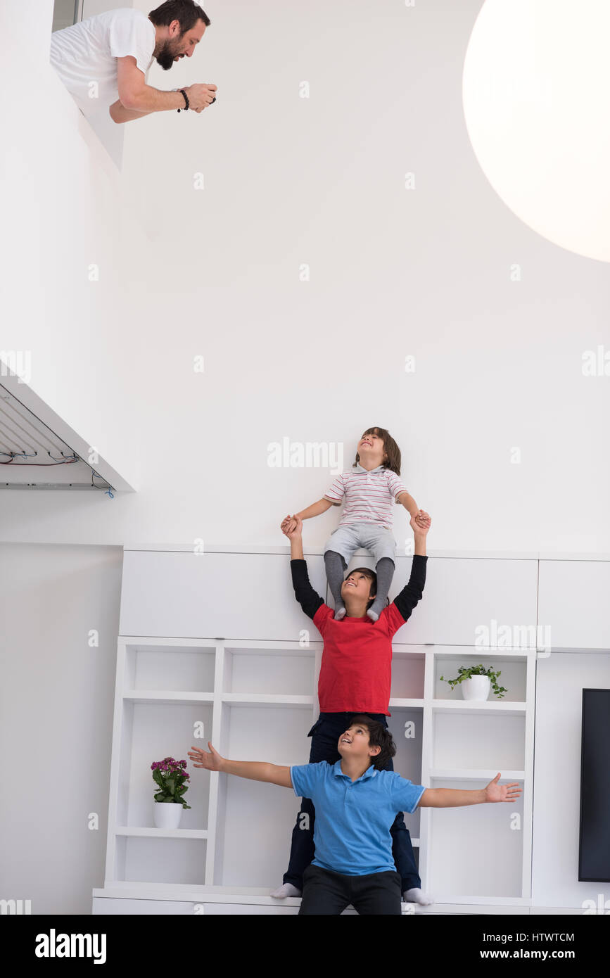 happy young boys having fun and posing line up piggyback in new modern ...