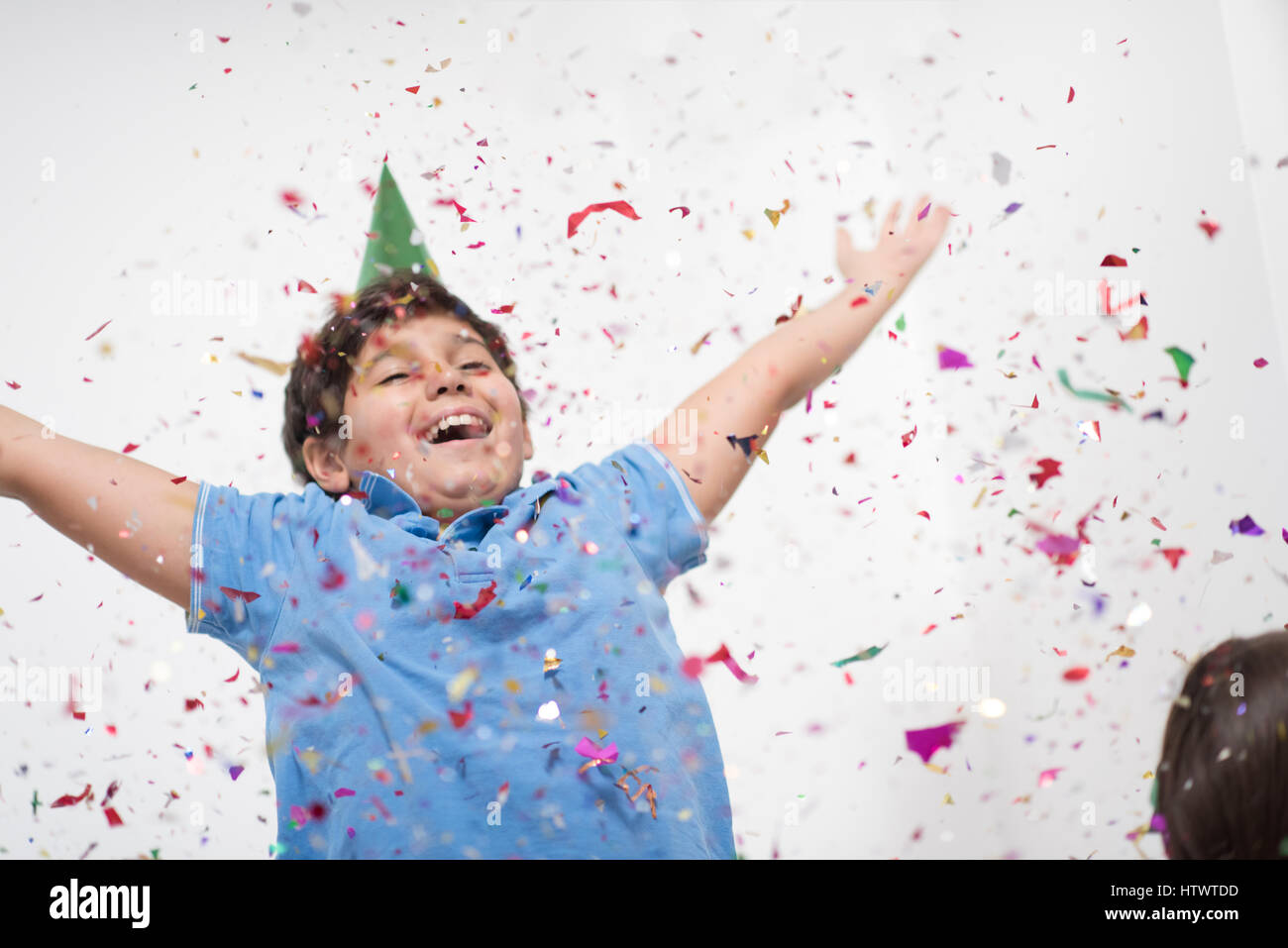 Happy kid celebrating party with blowing confetti Stock Photo - Alamy