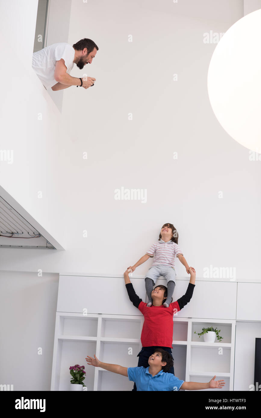 happy young boys having fun and posing line up piggyback in new modern ...